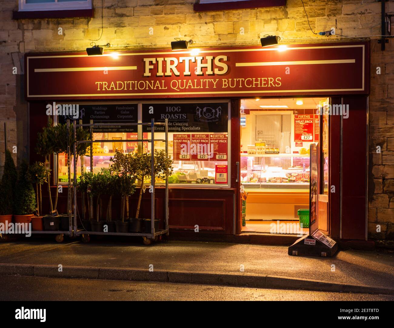 Nigh time view of a traditional butchers shop with illuminated sign ...