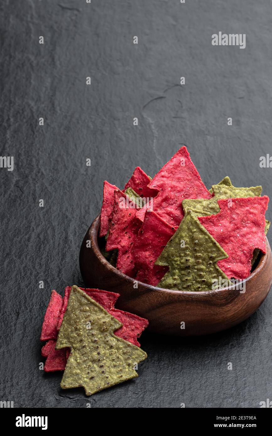 Christmas tree shapes tortilla corn crisps on black stone background ...