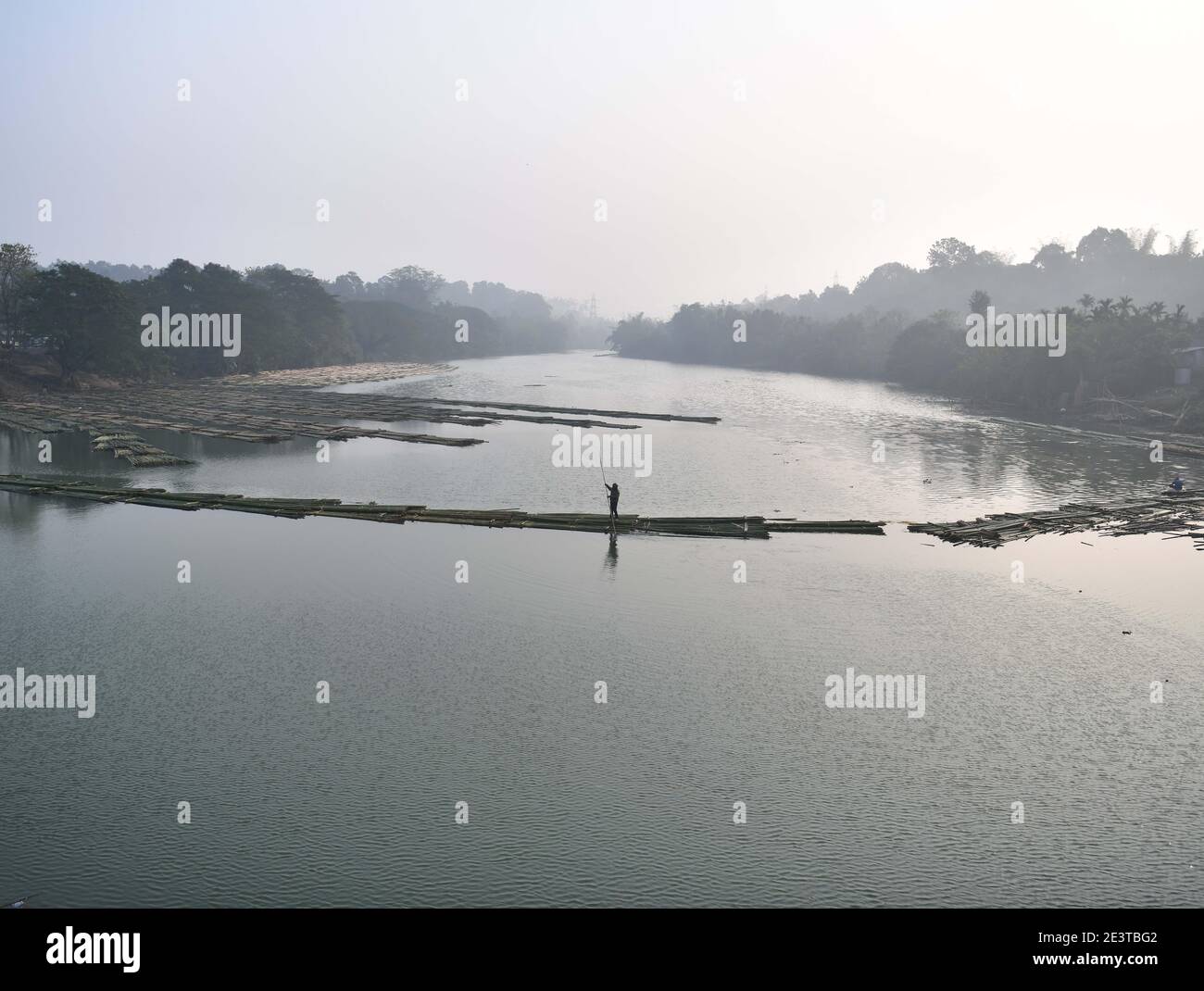 Laborers collect heaps of bamboo on a river to be sold at a floating ...