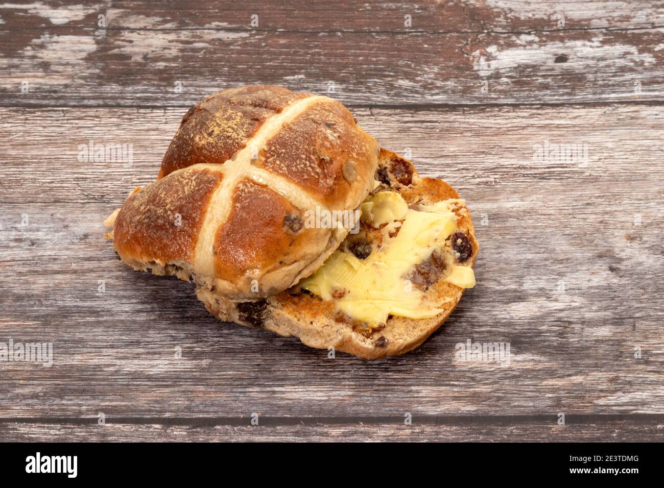 Hot cross bun with butter for Easter- white background Stock Photo - Alamy