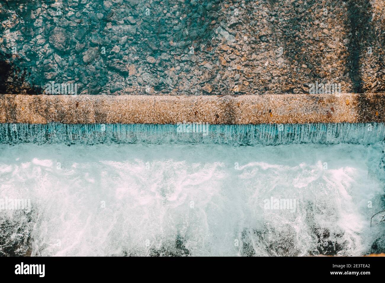 Top view of a river water stream falling from a dam Stock Photo - Alamy