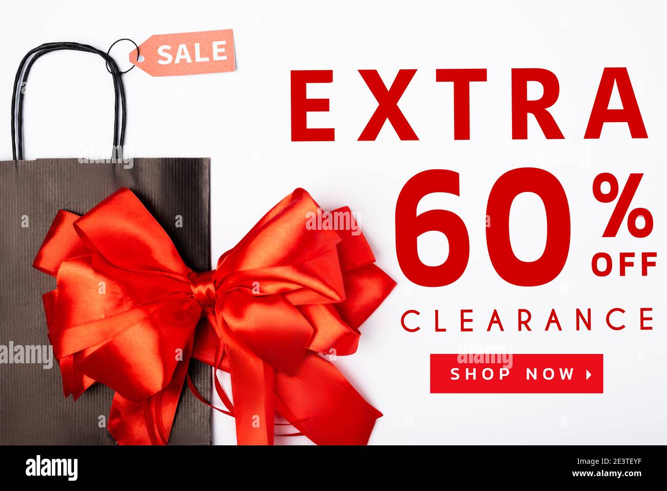 Top view of red bow on black shopping bag with price tag near extra 60 ...