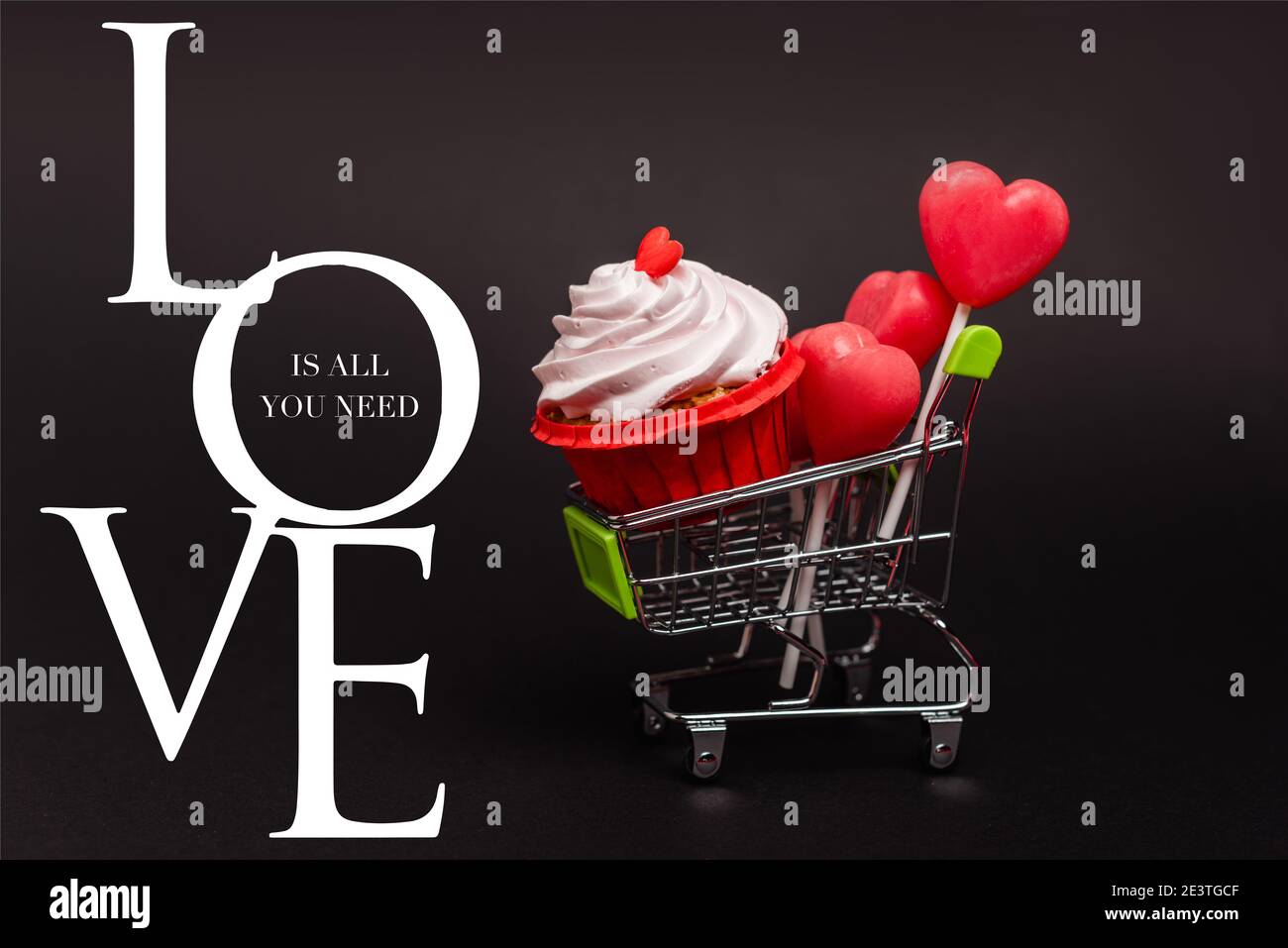 toy shopping cart with valentines, cupcake and lollipops near love is ...