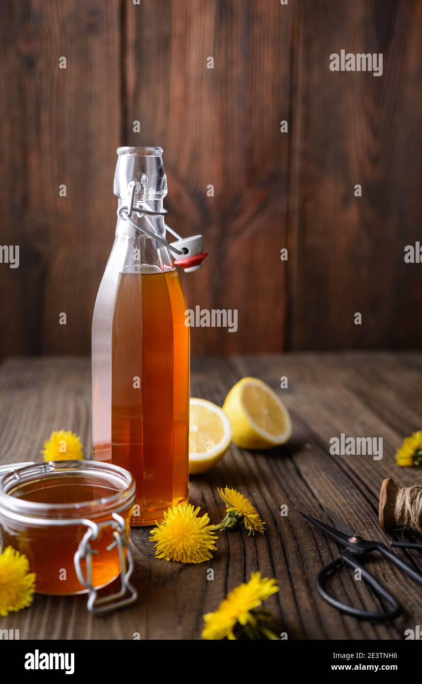 Homemade healthy dandelion syrup in a glass bottle, decorated with ...