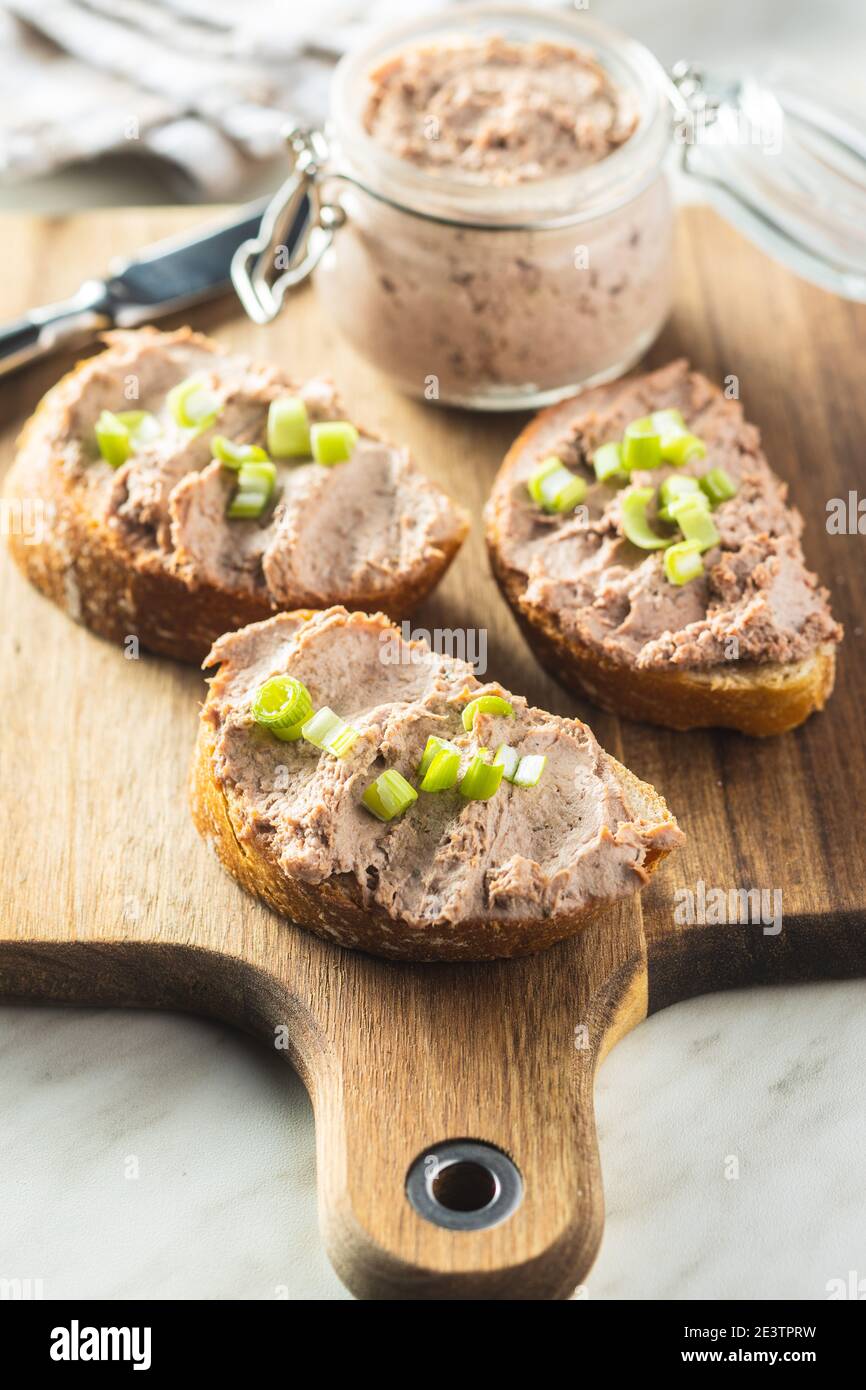 Liver pate on sliced baguette on cutting board Stock Photo - Alamy