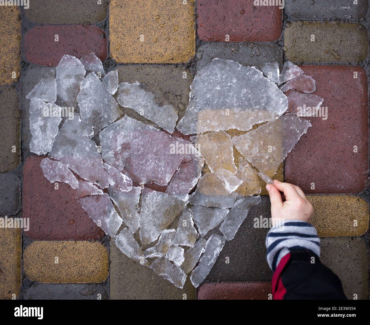 human hand collects a heart from transparent fragments of ice on the ...