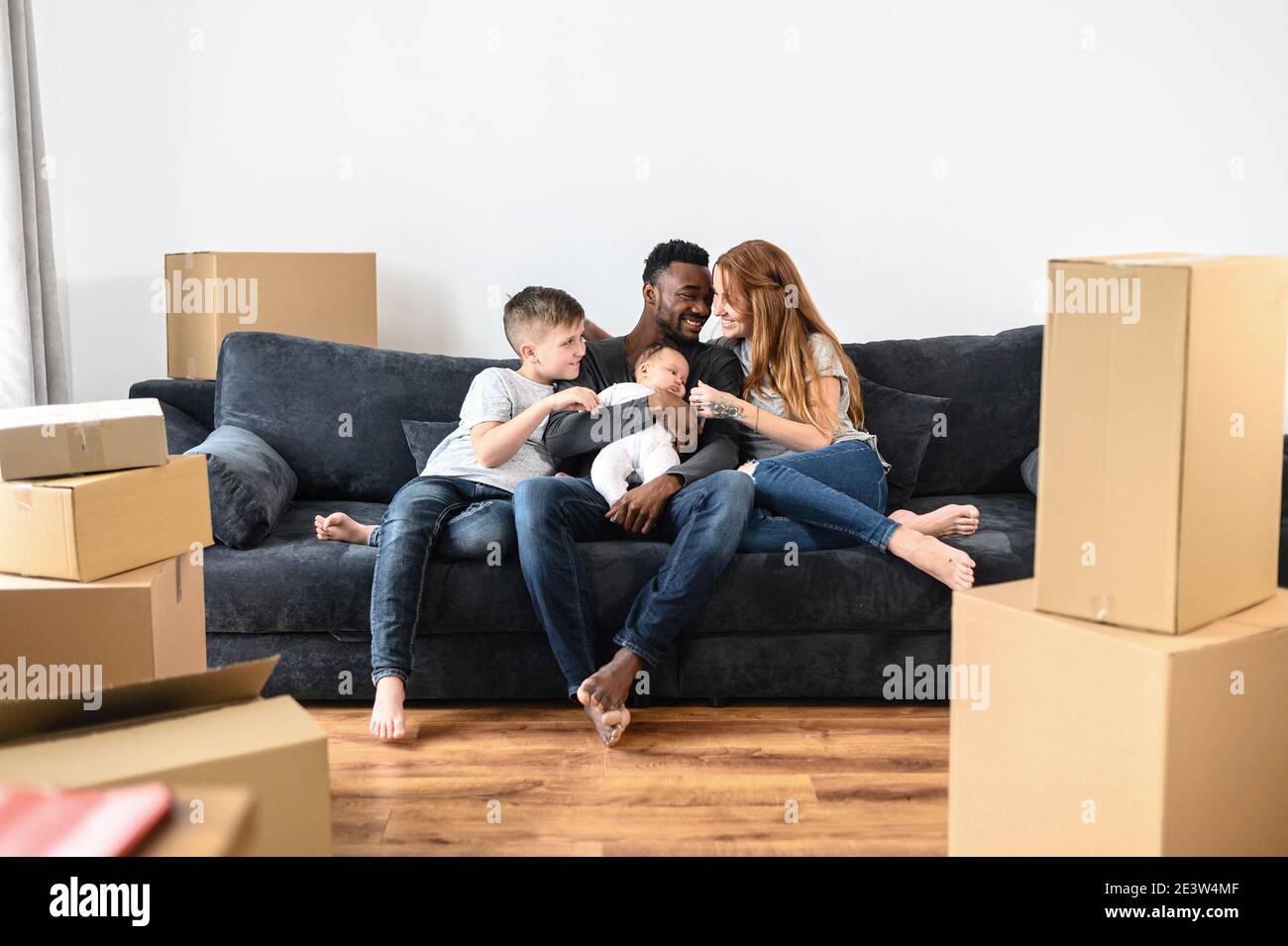 Multiracial family moving in a new house Stock Photo - Alamy