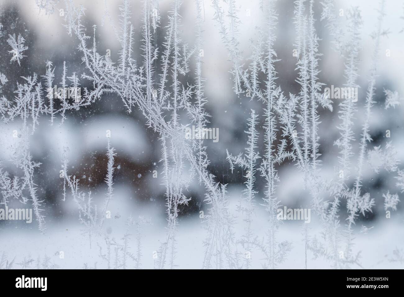 a cold and frosty winter morning through a window with icy patches ...