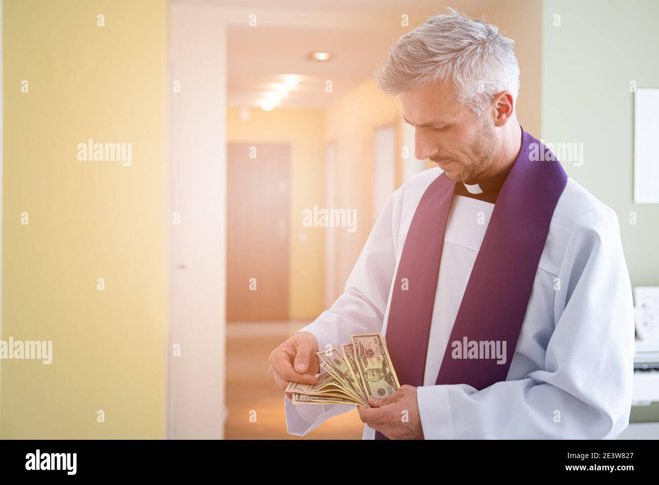 Catholic cleric priest counting american money dollar Stock Photo - Alamy