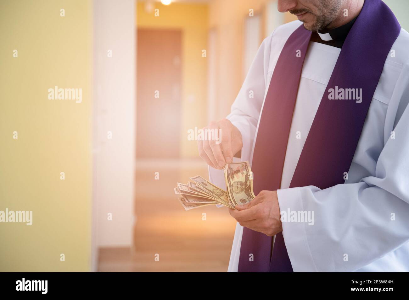 Catholic cleric priest counting american money dollar Stock Photo - Alamy