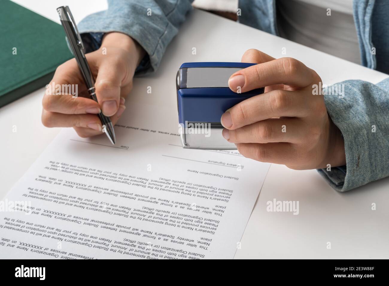 Business woman putting stamp on documents in the office - signing ...