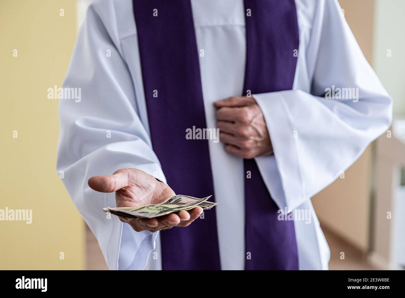 Catholic cleric priest counting american money dollar Stock Photo - Alamy