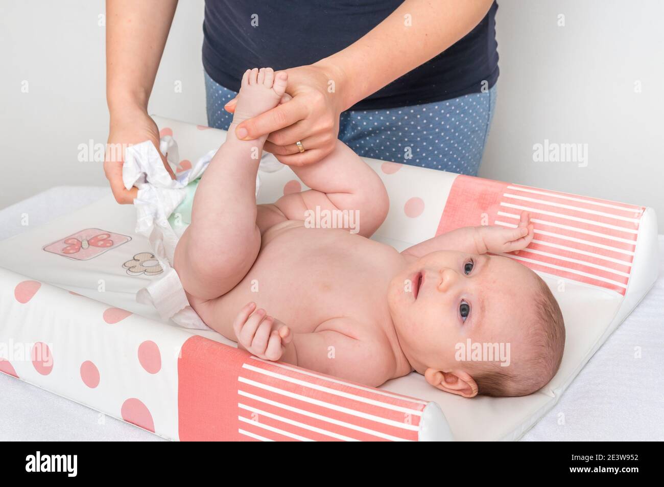mother-is-changing-diaper-to-her-little-baby-in-child-room-at-home