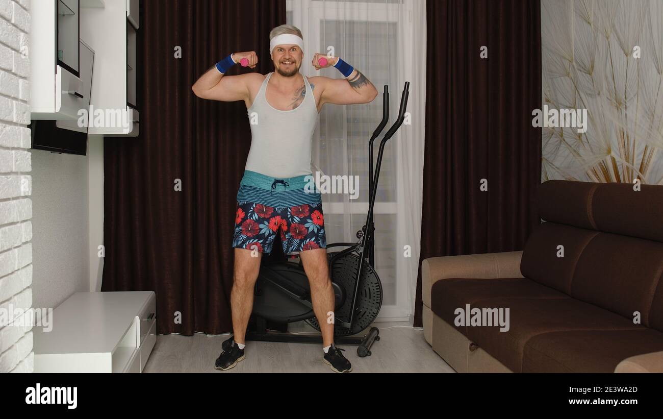 Funny bodybuilder sportsman guy couch showing biceps. Stylish hipster ...