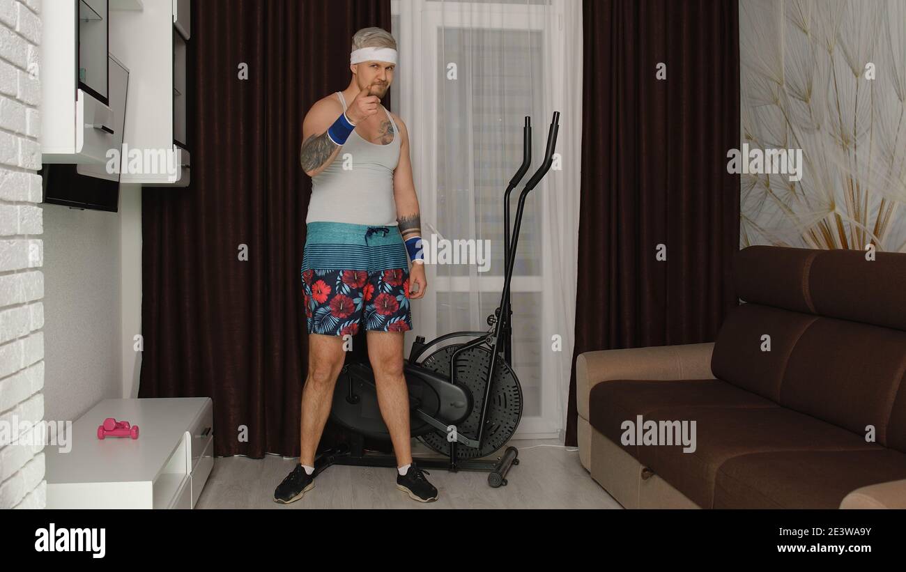 Sportsman retro guy in funny clothes is running in place at home making ...
