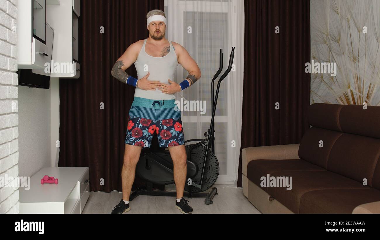 Funny fat sportsman man athlete in sportswear making sport fitness ...