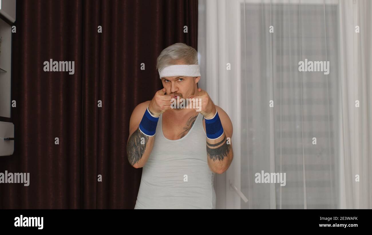 Funny bodybuilder sportsman guy couch showing biceps. Stylish hipster ...