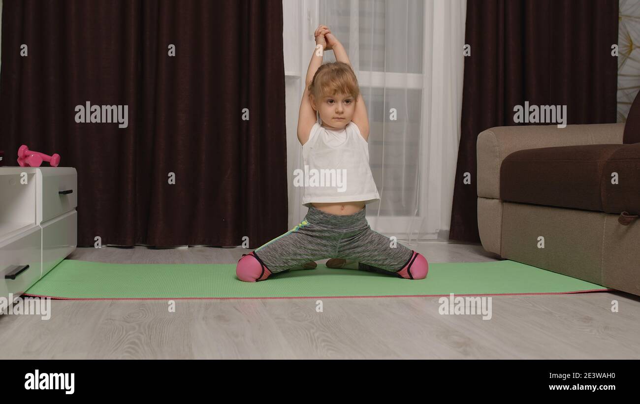 Child kid girl doing gymnastics fitness stretching workout at home ...