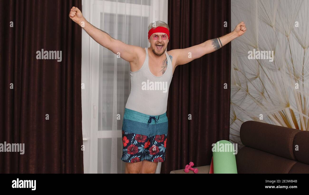Sportsman retro guy in funny clothes dancing at home making sport ...
