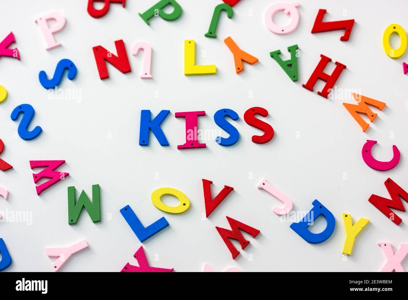 Kiss - a word of multicolored letters on a white table, Flat Lay ...