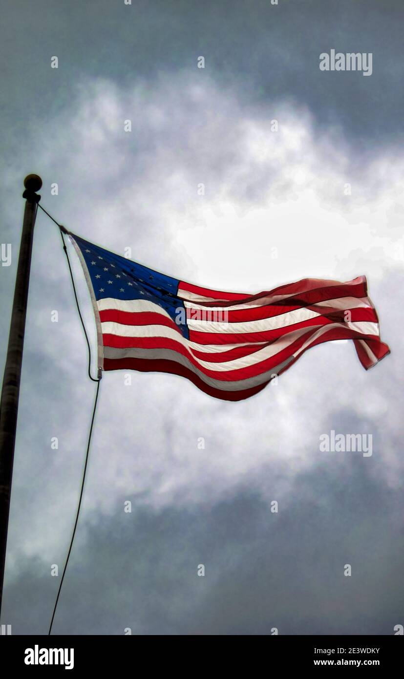 American flag flaps in the wind on a dark breezy day Stock Photo - Alamy