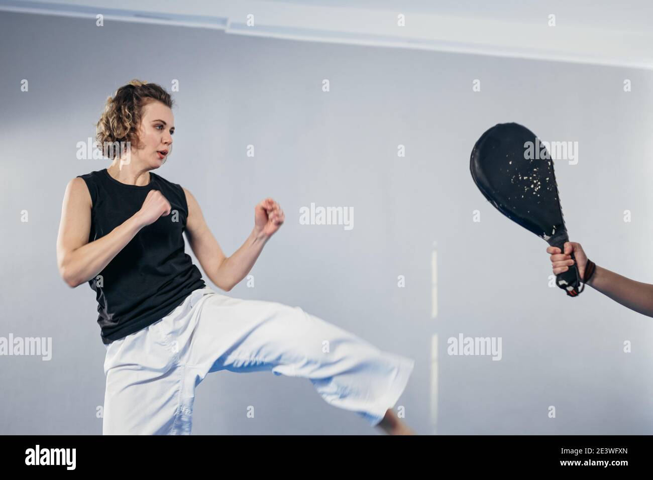 Female martial arts fighter practicing with trainer, punching taekwondo ...