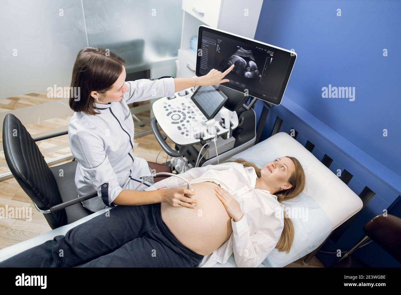 Young professional female ultrasound technician, obstetrician doctor ...