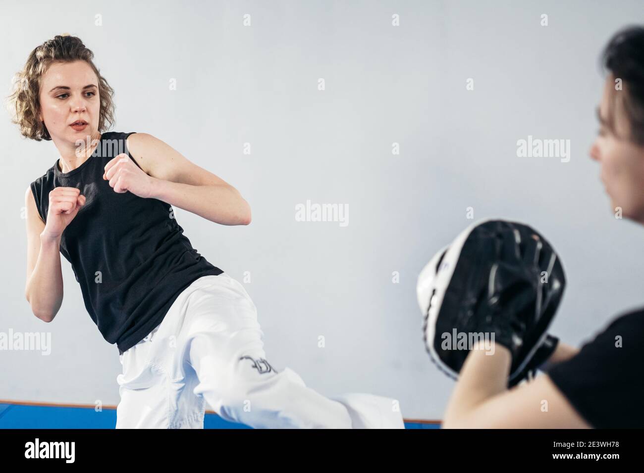 Personal training martial art of taekwondo. Female trainer holding ...