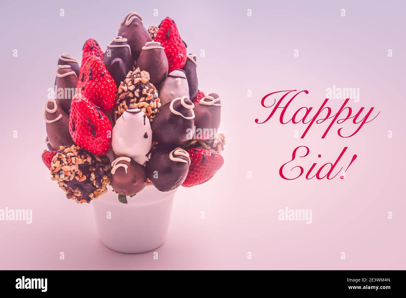 Happy Eid greeting card with red lettering; A bunch of edible flowers ...