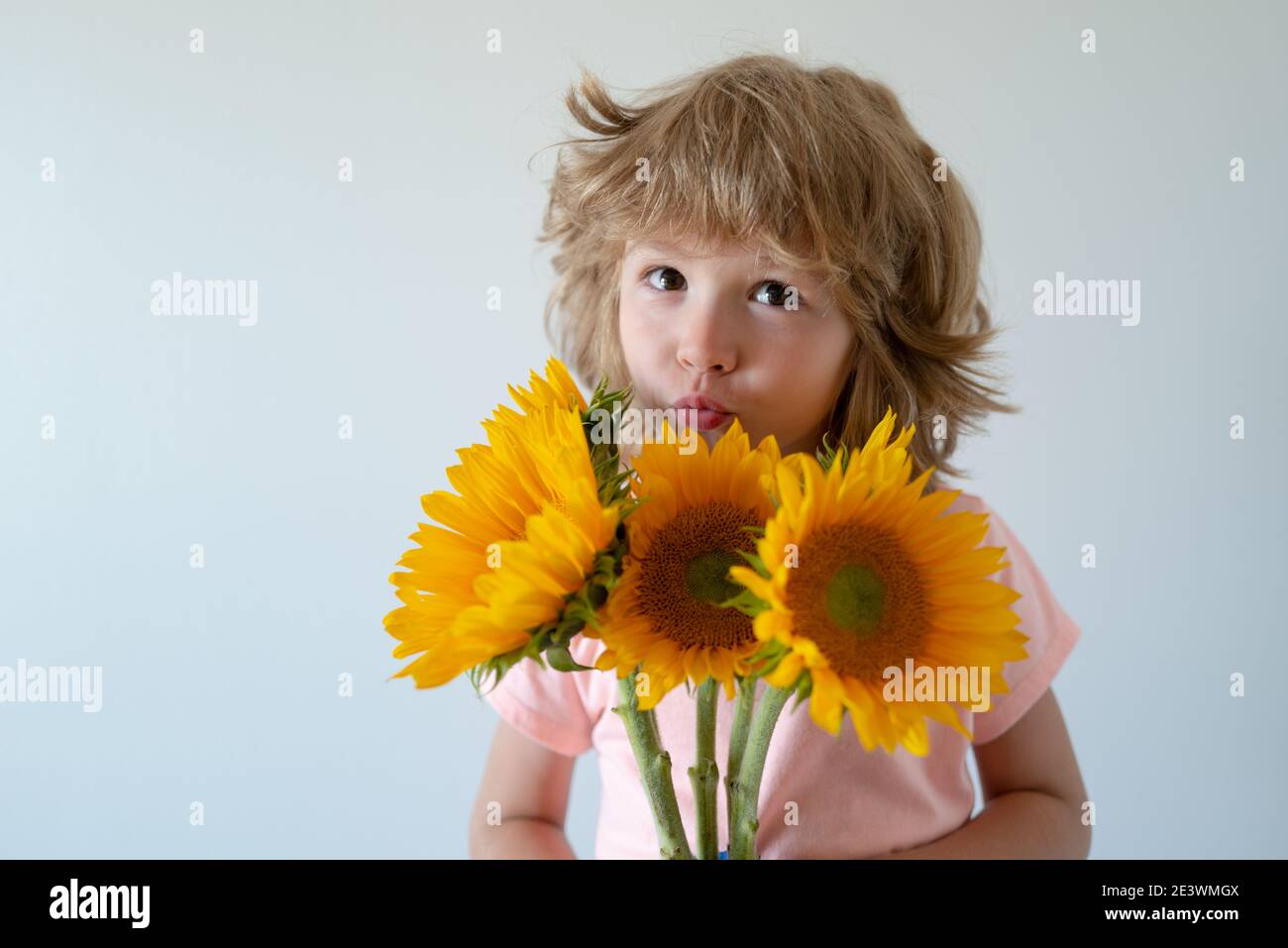 Smiling kid with sunflowers. Happy child with bouquet of flowers. Cute ...