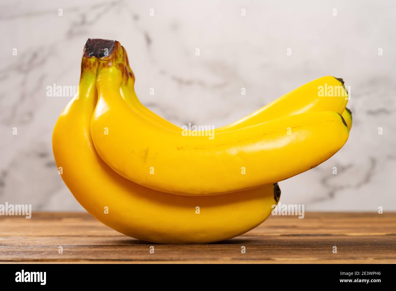 side view artificial bananas on a wood table Stock Photo - Alamy