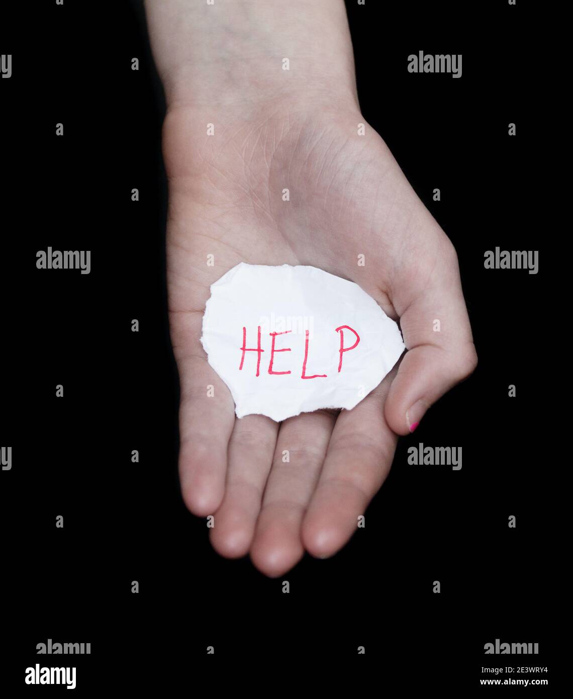 Girl holds a note with the word help in her hand Stock Photo - Alamy