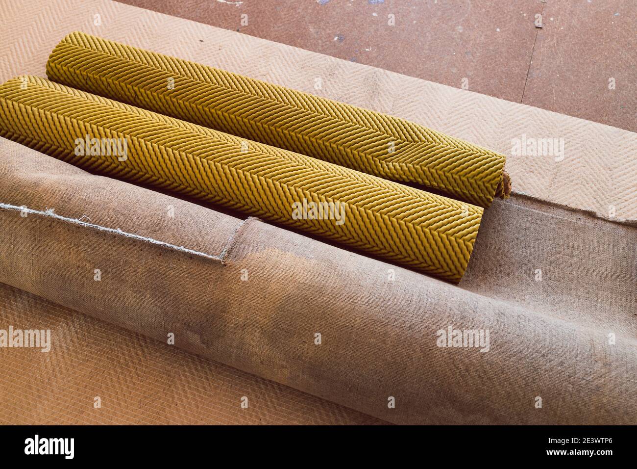 home improvement and DIY concept, ripped up and rolled up carpet and ...
