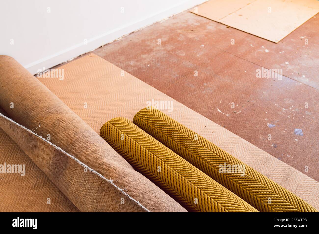 home improvement and DIY concept, ripped up and rolled up carpet and ...