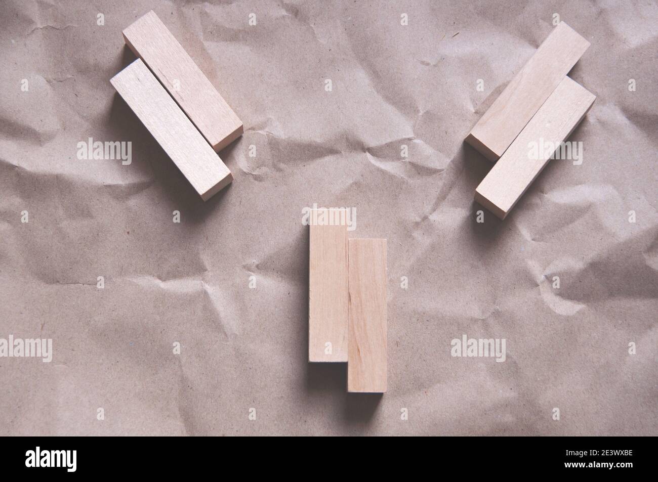 background of crumpled craft paper with wooden rectangles arranged in a ...