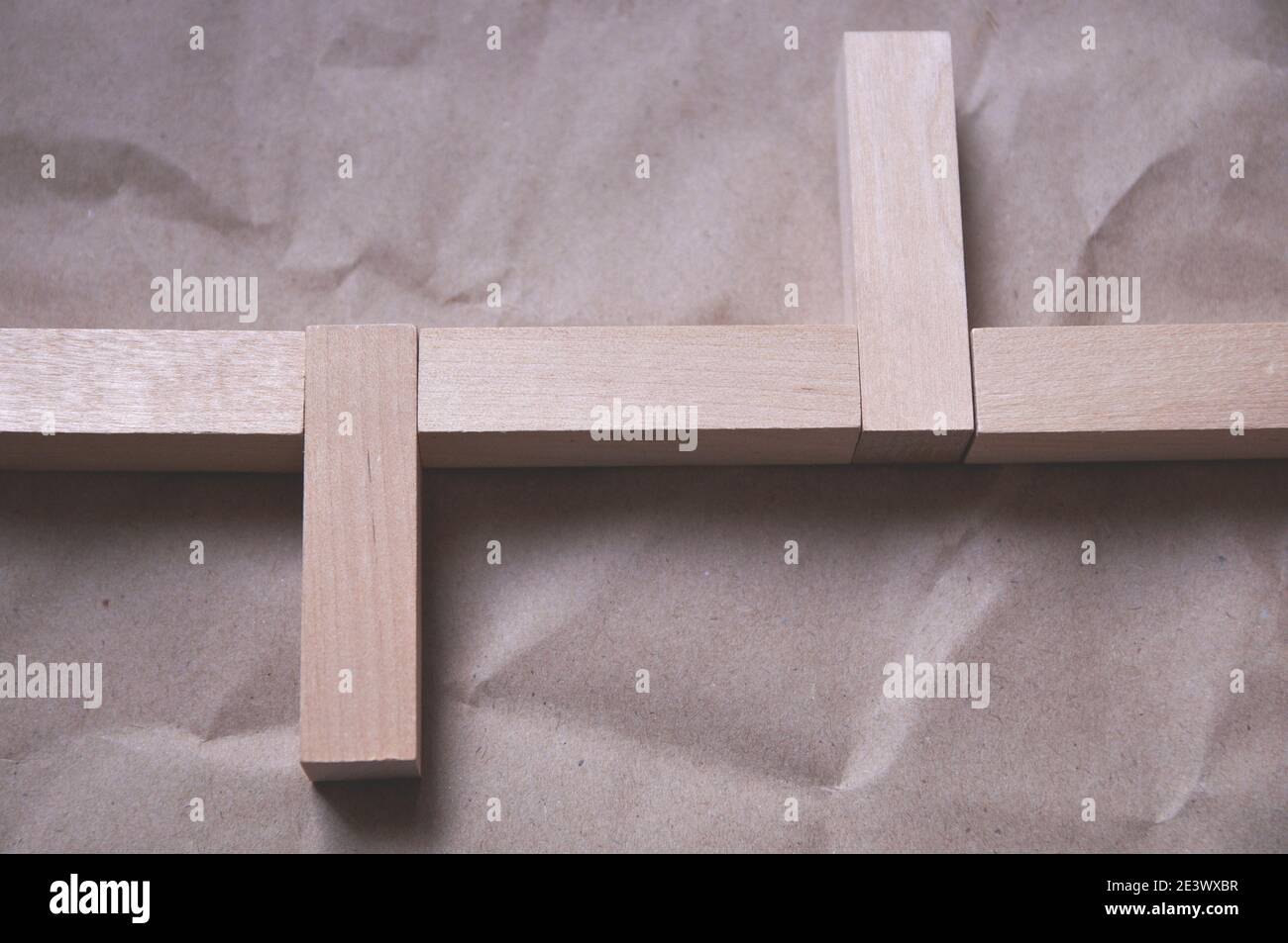 background of crumpled craft paper with wooden rectangles arranged in a ...