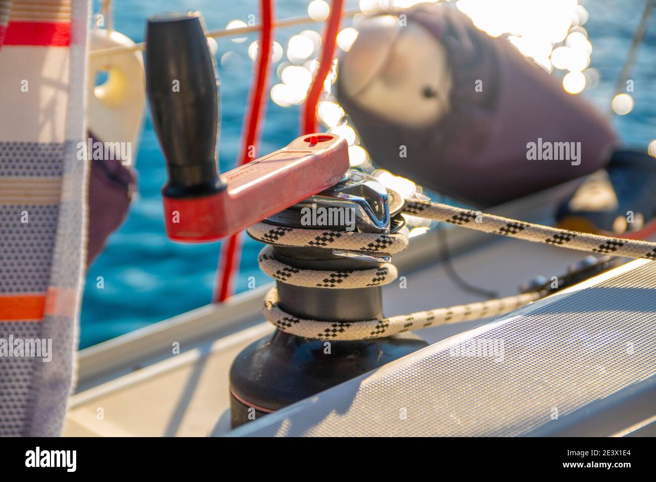 Close up of a winch with focus on a rolled black striped white rope ...