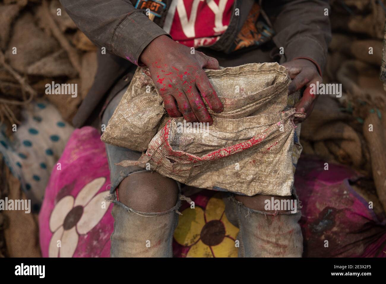 Neu Delhi, India. 18th Jan, 2021. A young rag picker rests while ...