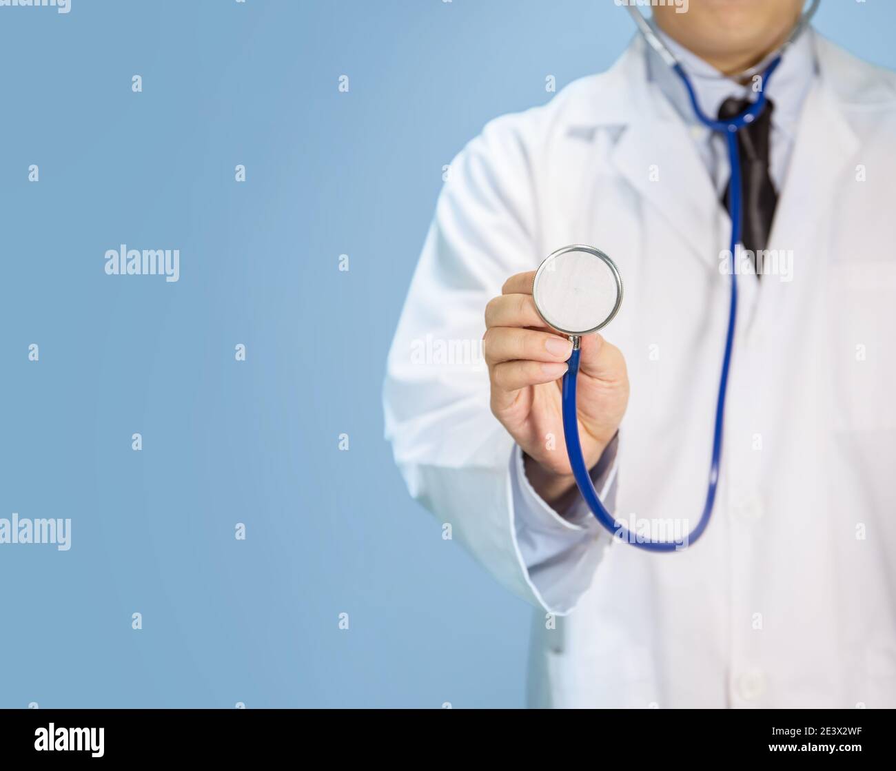 Doctor in empty blue background with copy space Stock Photo - Alamy