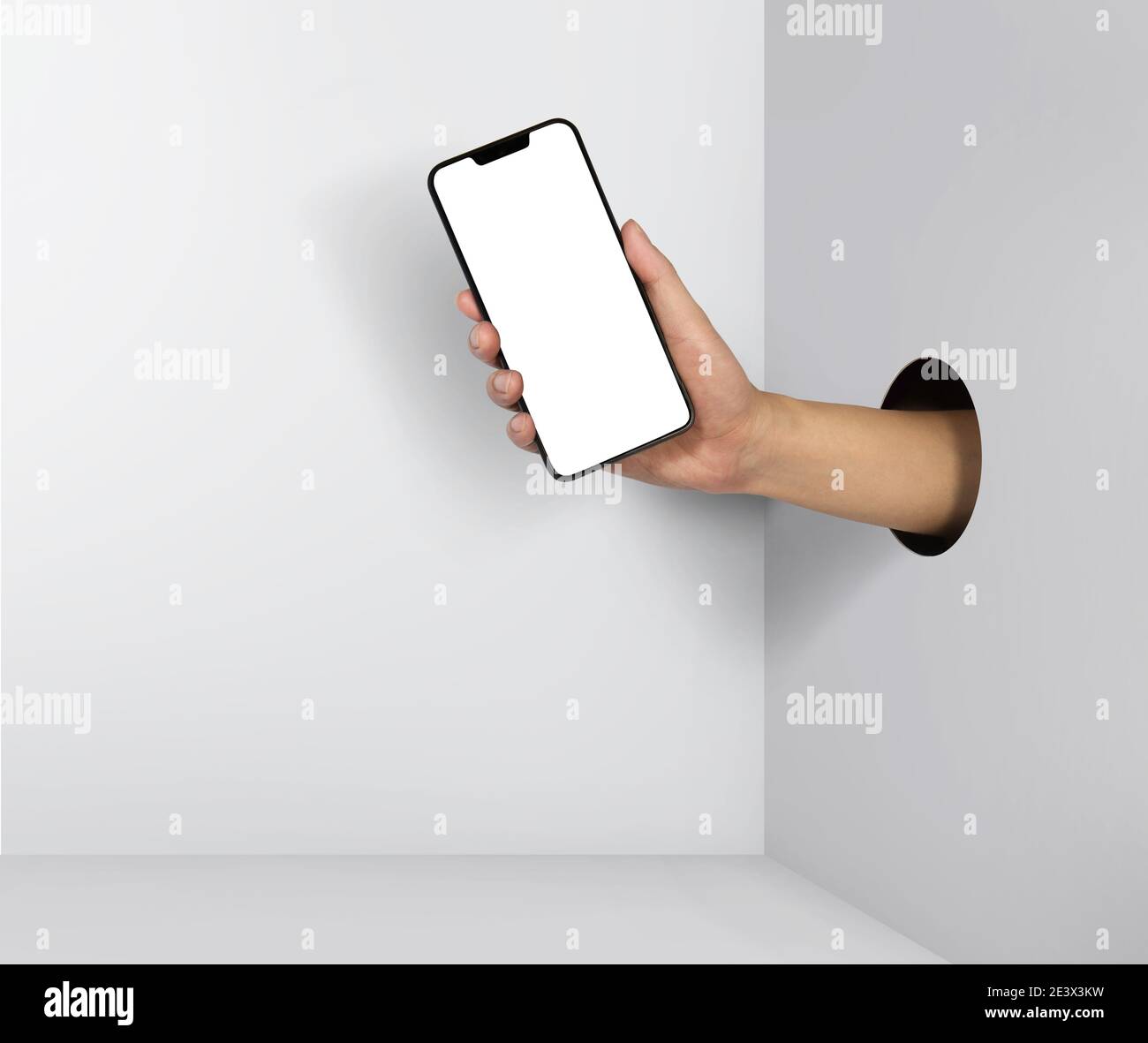 Man holding smartphone with blank screen in hand through hole on white ...