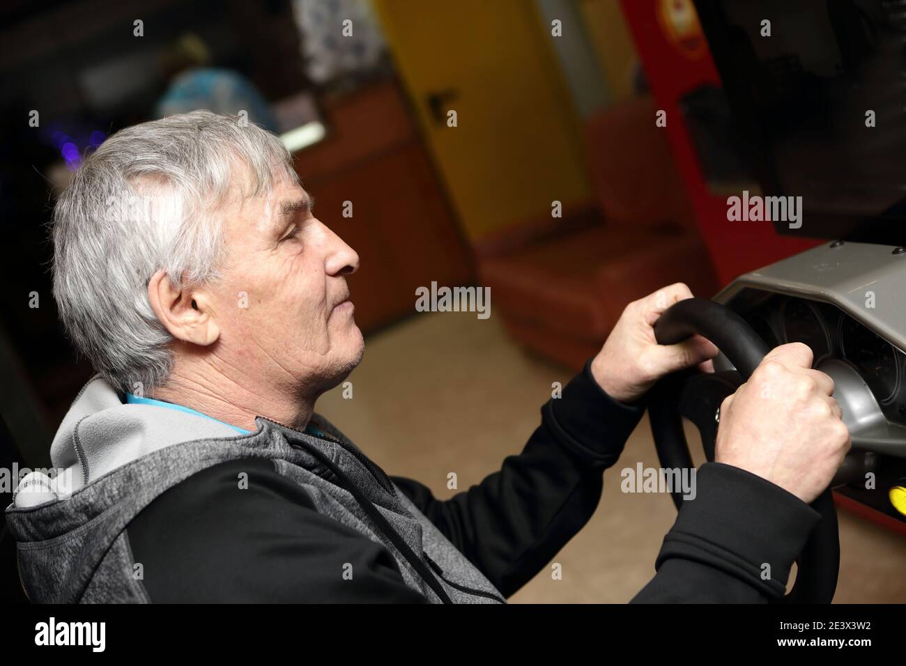 Man playing with car simulator in the amusement park Stock Photo - Alamy