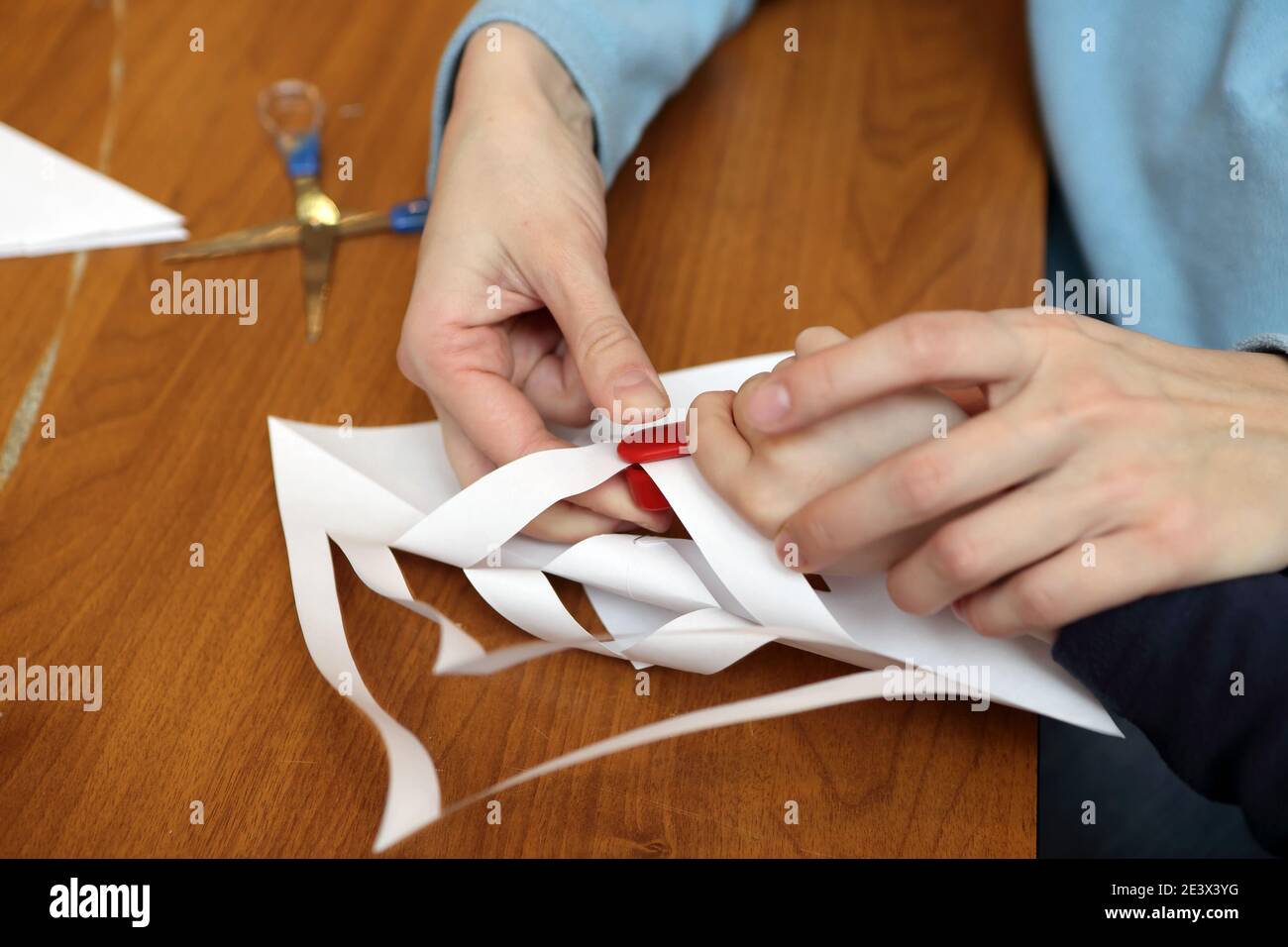 A person making paper snowflake at workshop Stock Photo - Alamy