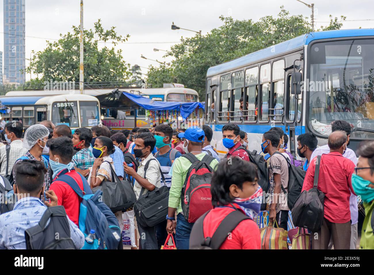 People gathered in the bus stand waiting for the bus with masks during ...