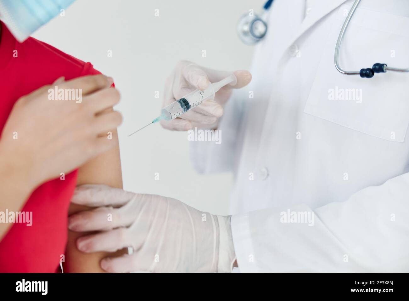 doctor injecting an injection into the shoulder coronavirus vaccination ...