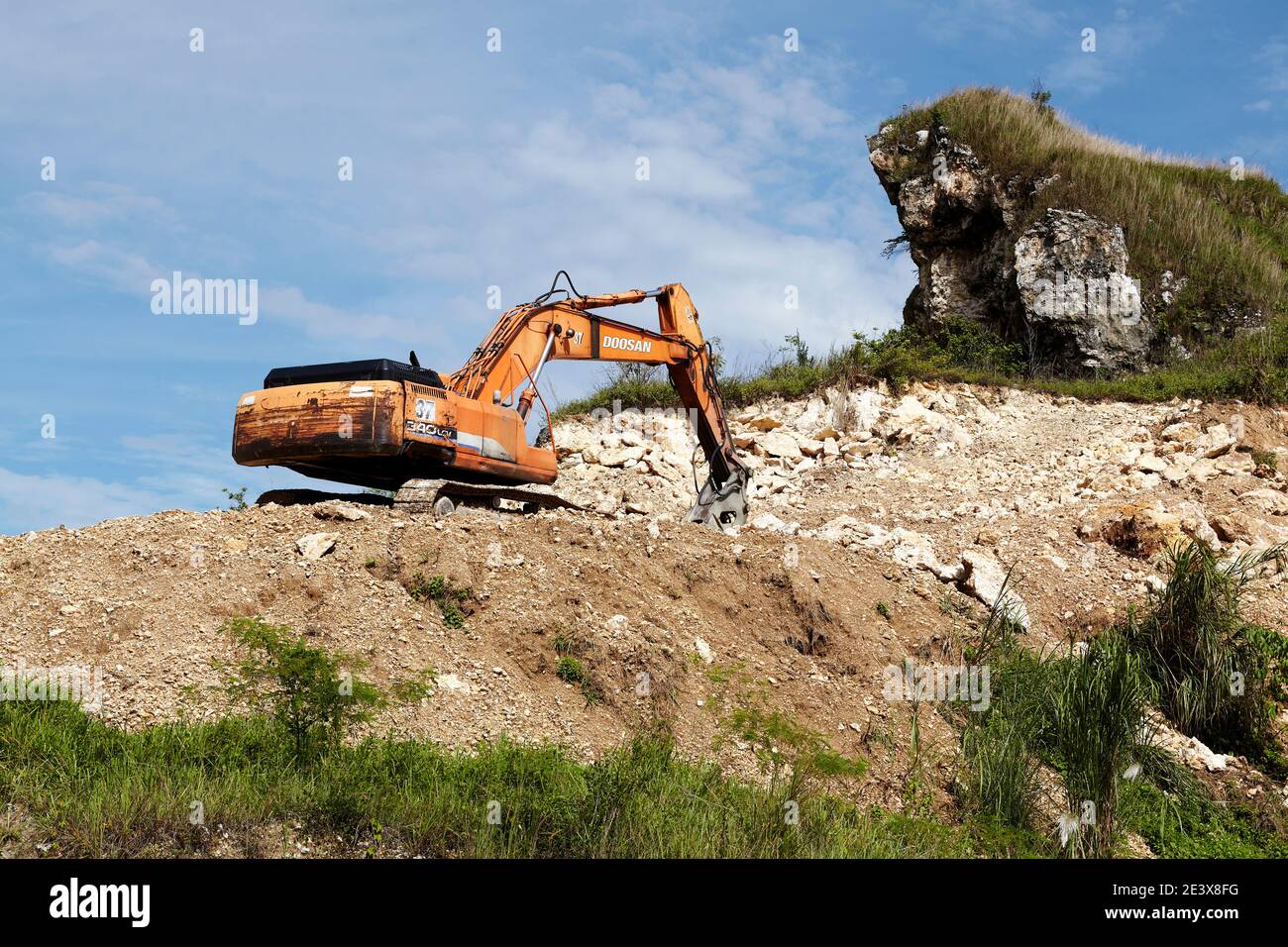 An excavator is collecting limestone at a limestone quarry Stock Photo ...