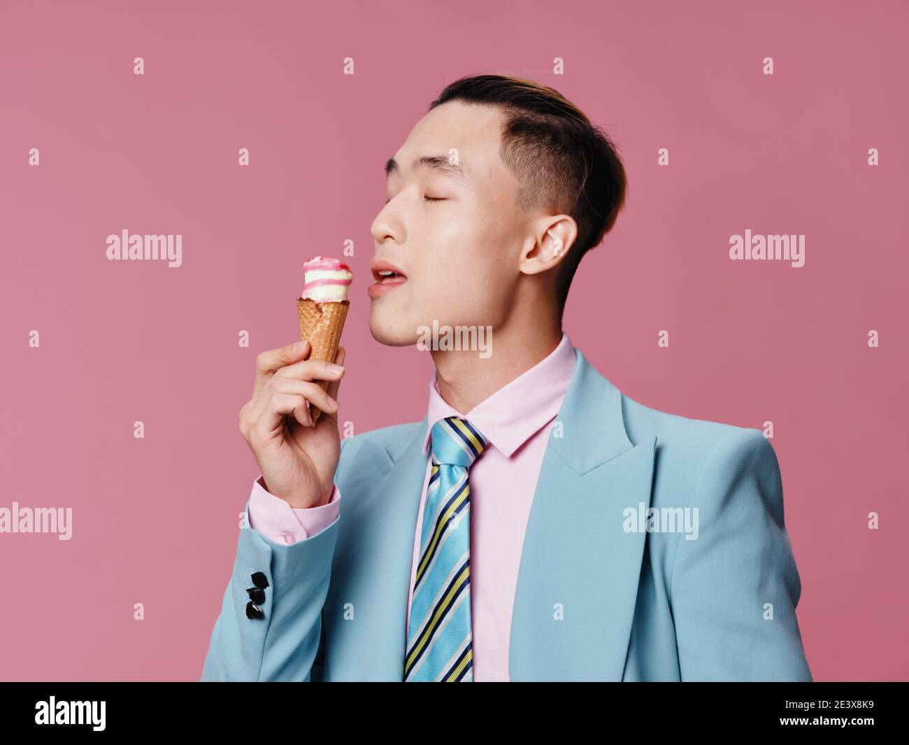 Cheerful man in blue suit ice cream enjoyment pink background Stock ...