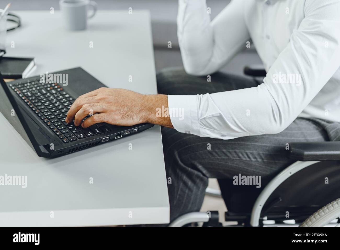 Disabled man in a wheelchair using laptop Stock Photo - Alamy