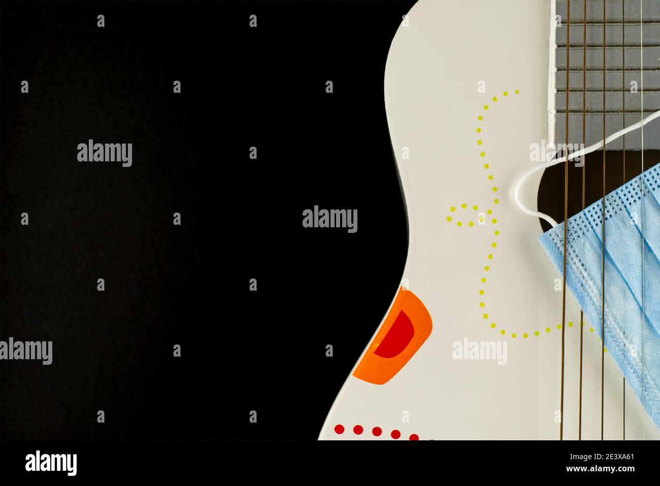 Wooden acoustic guitar body and a face mask between the strings over a ...