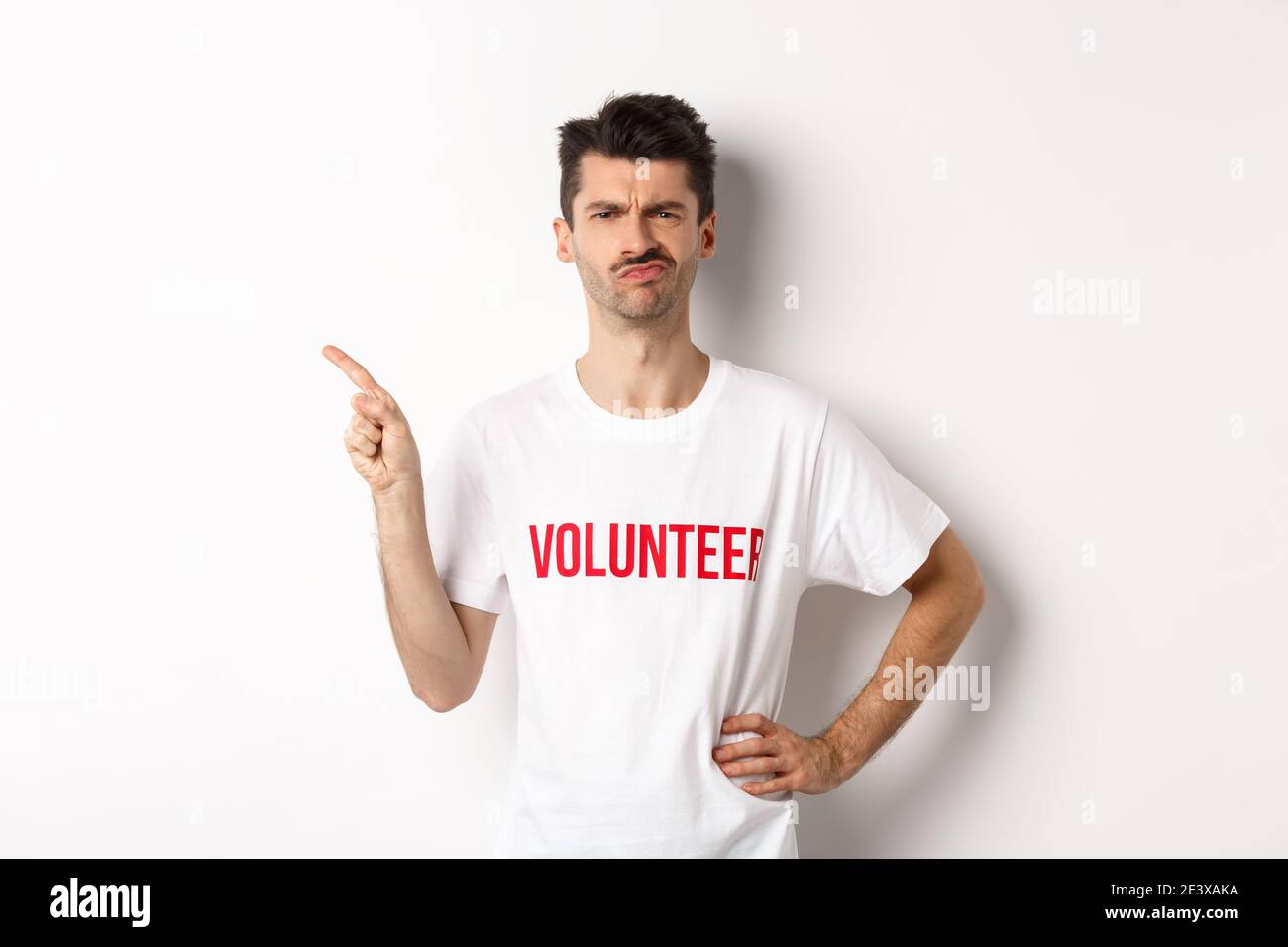 Skeptical and hesitant male volunteer in t-shirt grimacing doubtful ...