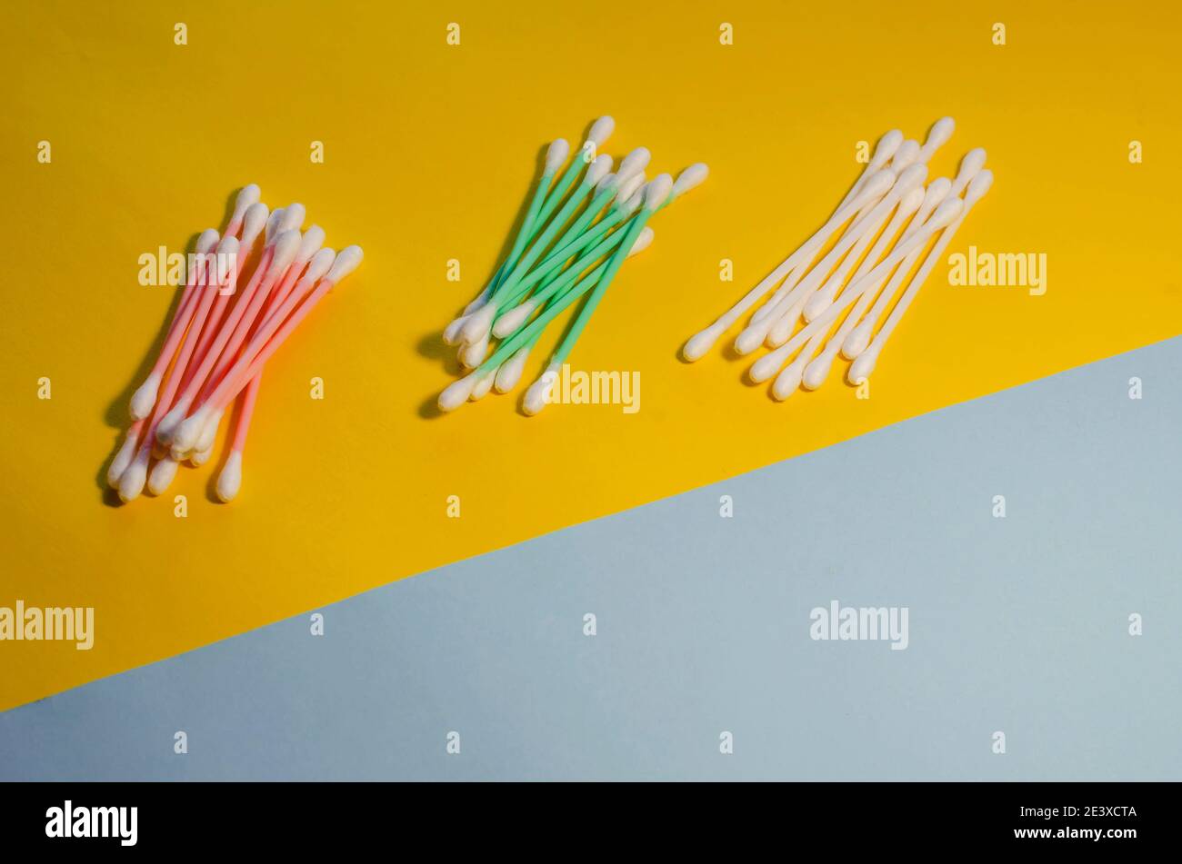 Minimalist background with cotton swabs of different colors on a two ...